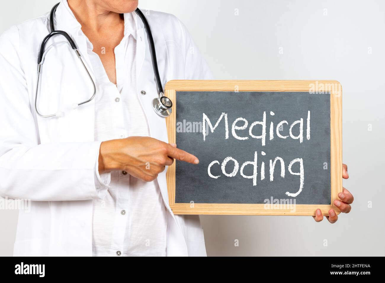 Blackboard with ''Medical coding'' written on it in the hands of a ...