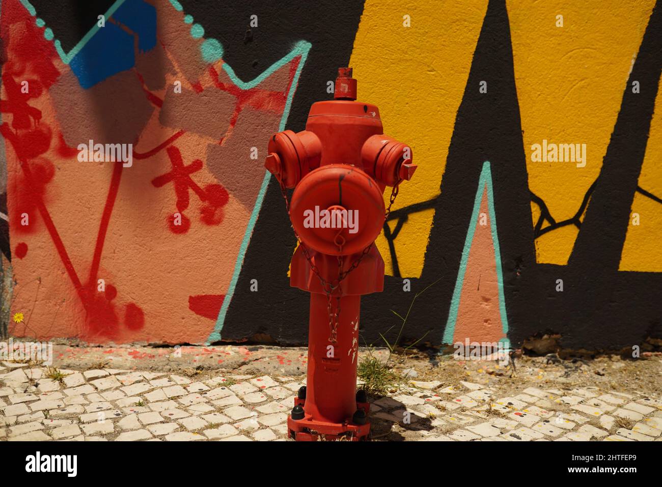 Closeup of a street hydrant near a wall with graffiti Stock Photo - Alamy