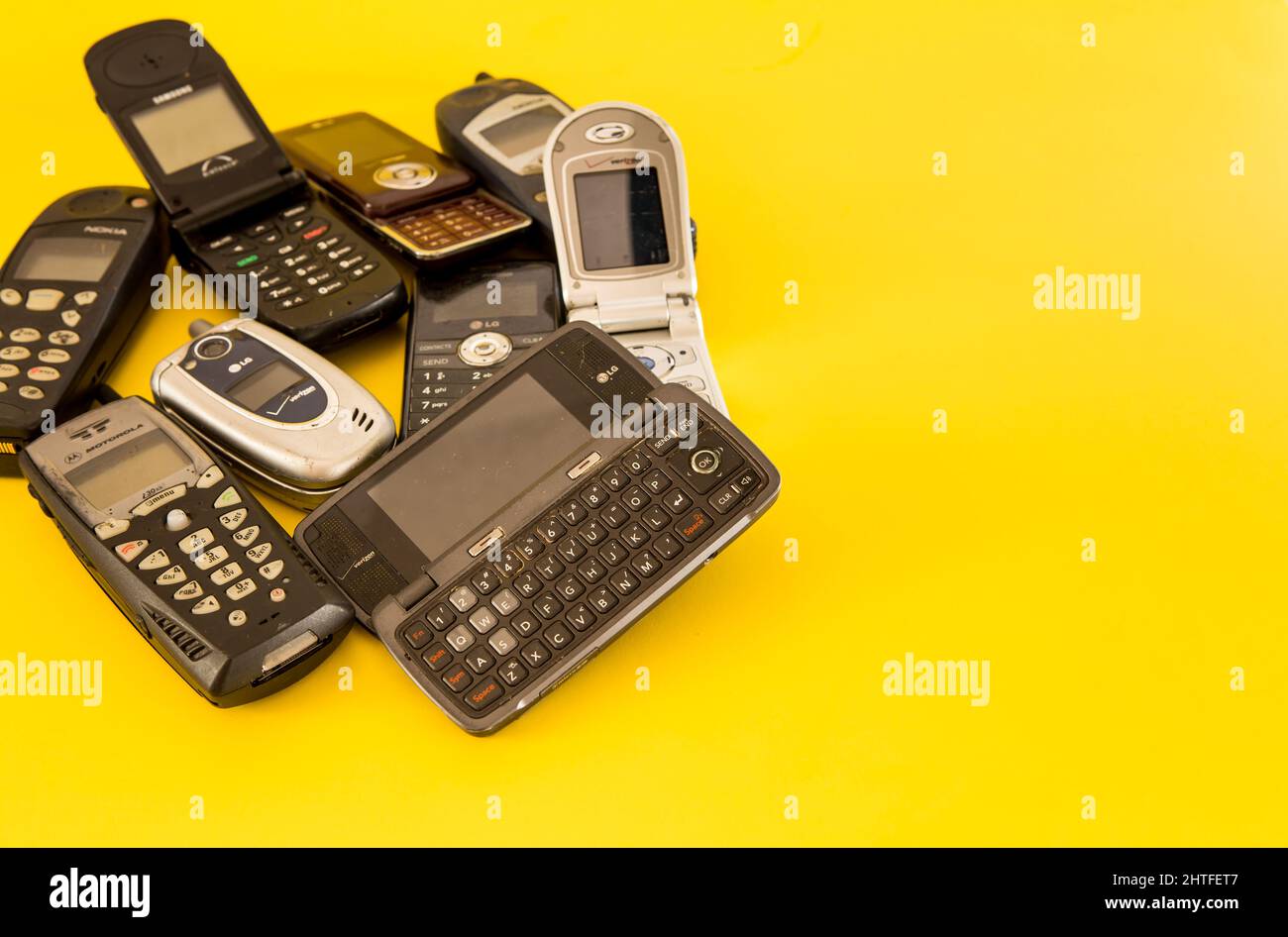 Old cell phones and mobile phones on a yellow background with copy ...