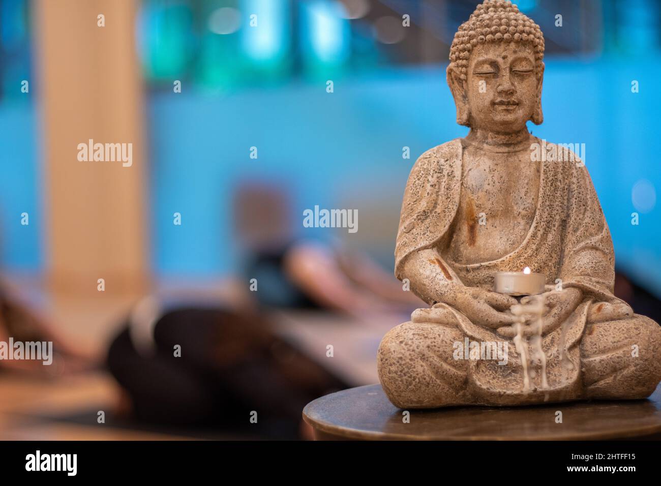 Buddha statue in front of people doing yoga Stock Photo - Alamy