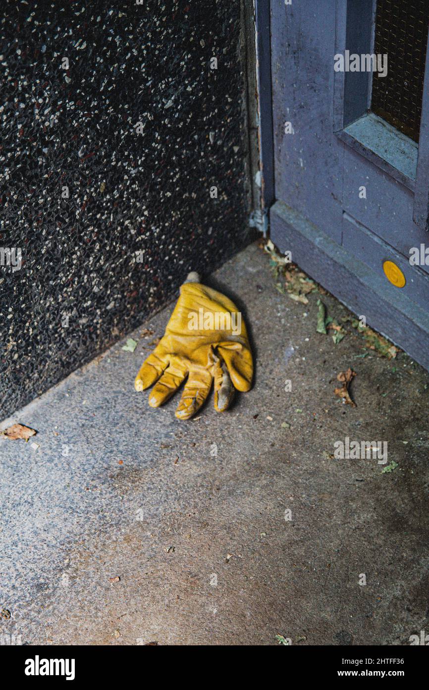 A vertical shot of an old working glove on the ground Stock Photo - Alamy