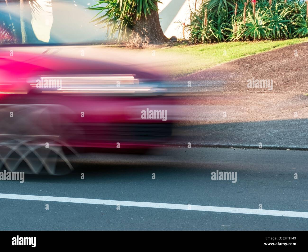blurred red car in suburban street on bright summer day Stock Photo - Alamy