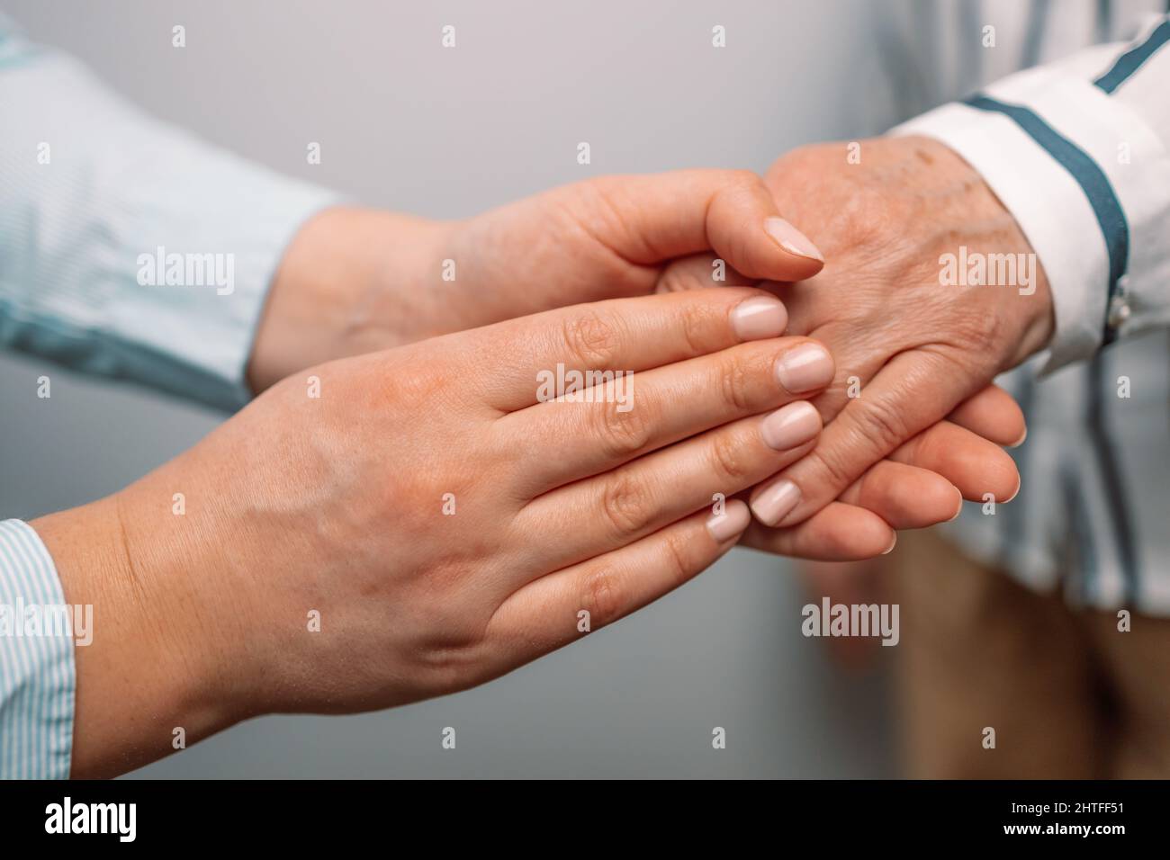 Unrecognizable senior and young holding hands s for comfort and ...
