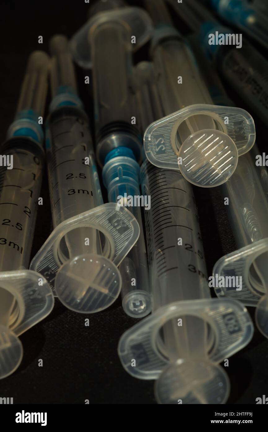 Vertical photo of a set of syringes on a black surface Stock Photo - Alamy