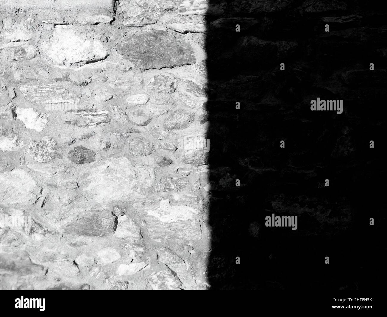 stone wall half in light and half in shadow in black and white Stock ...