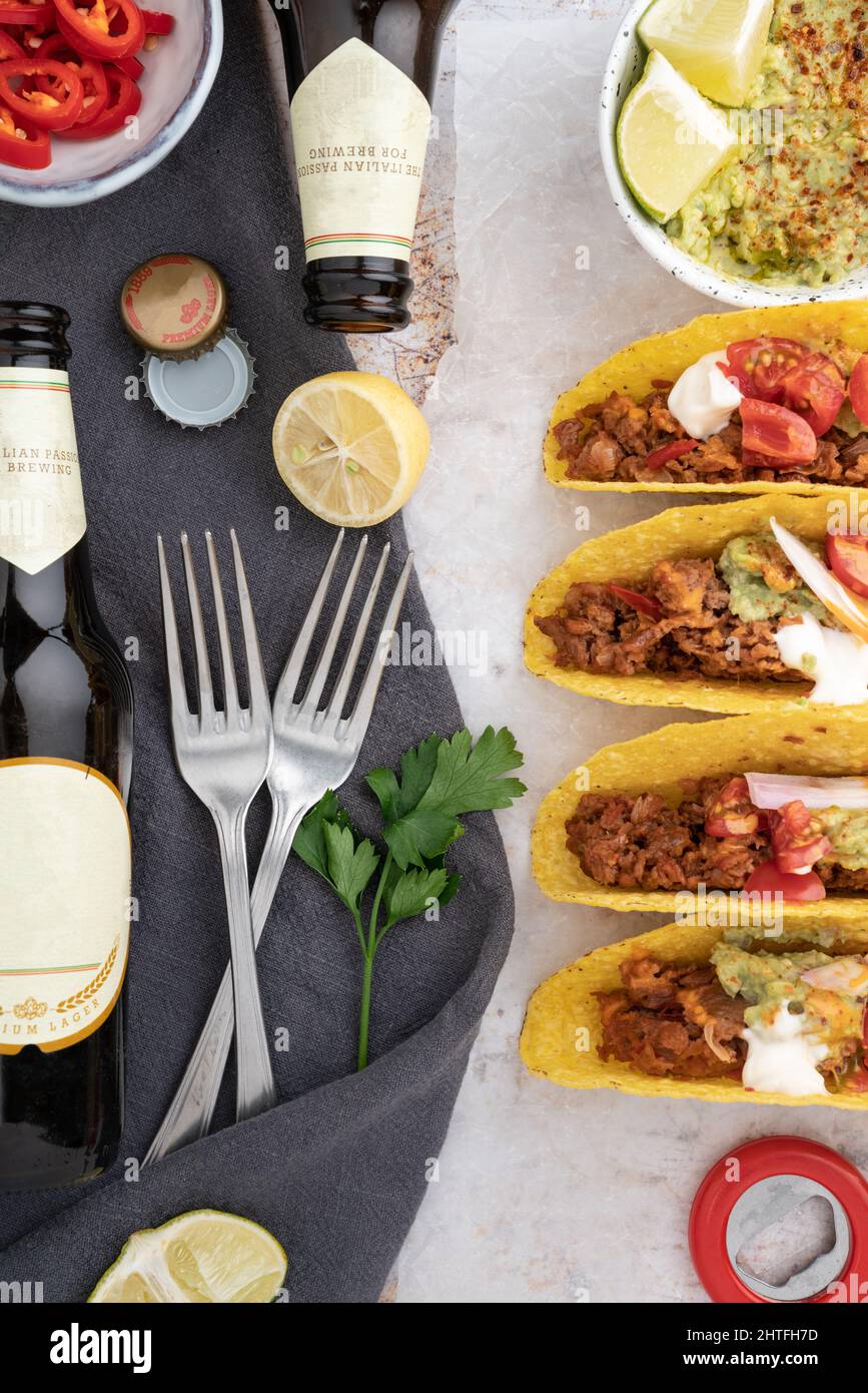 Serving of delicious Mexican tacos with bottles of beer and some ...