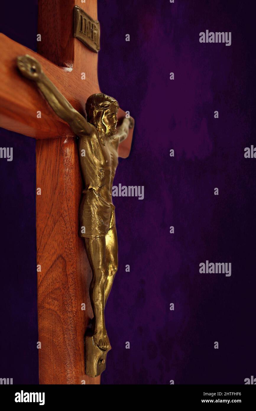 Side view of crucifix on purple background Stock Photo - Alamy