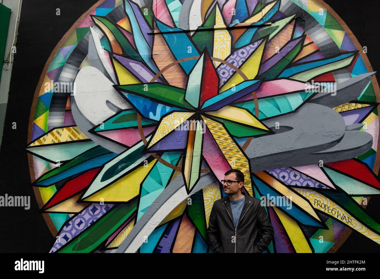 Guy standing in front of cool graffiti mural painted in the mission ...