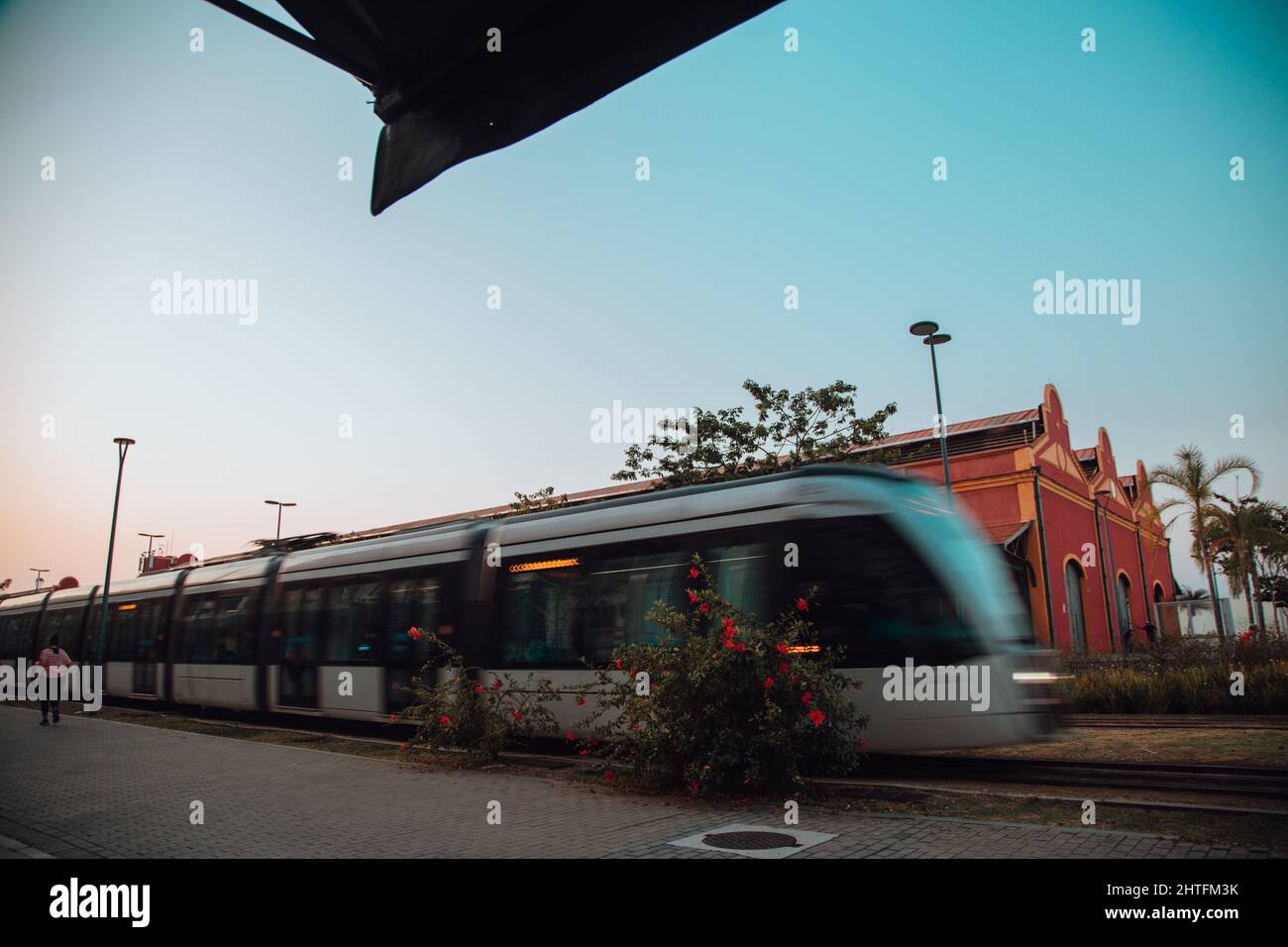 View of a motion metro subway train in the station against a light blue ...