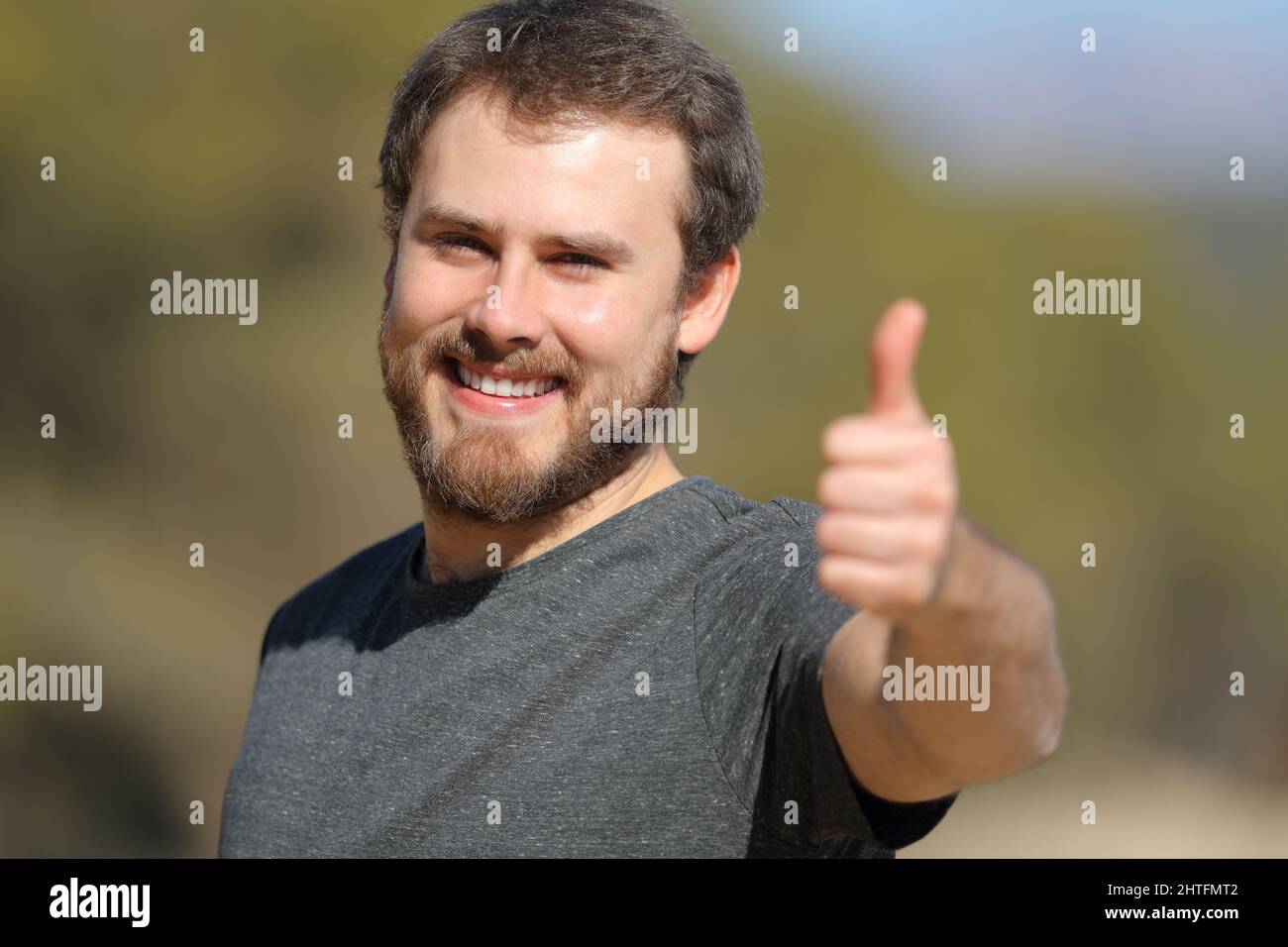 Front view portrait of a happy man gesturing thumbs up at camera in ...