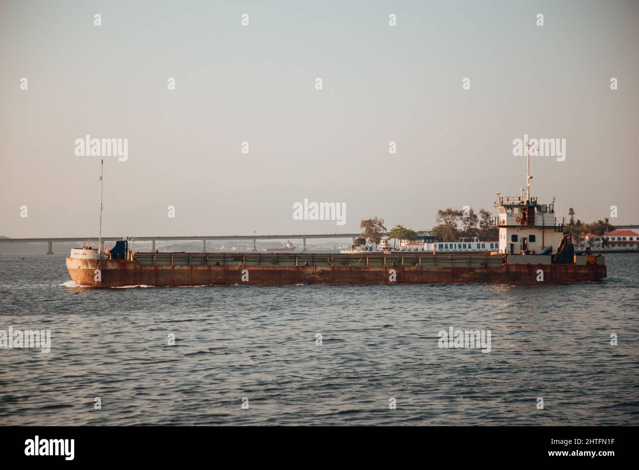 View of a small cargo ship in the sea against a gray sky Stock Photo ...