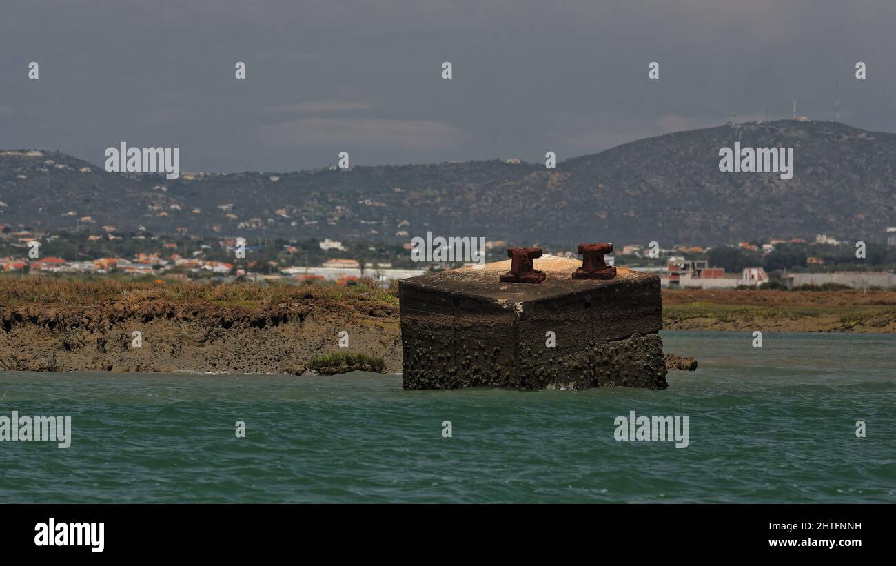 Rusty bollards-concrete block-detached piece of jetty-Ria Formosa-St ...