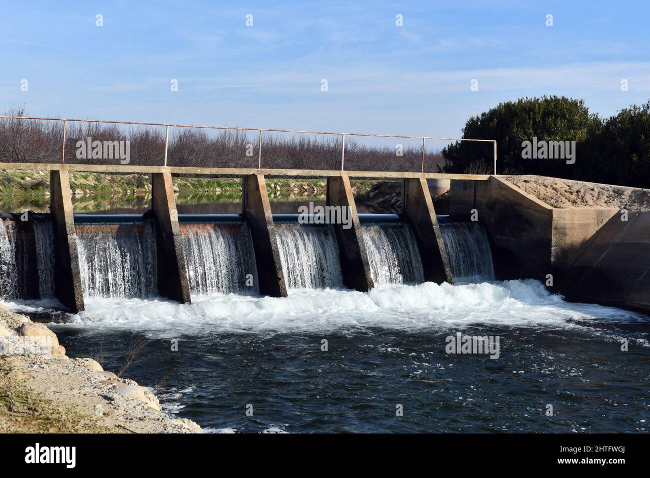 Water splashing through a dam over a river Stock Photo - Alamy