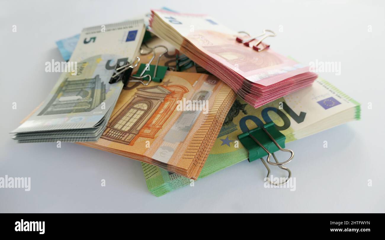 stacks of euro banknotes stuck together by a letter foldback clip piled ...