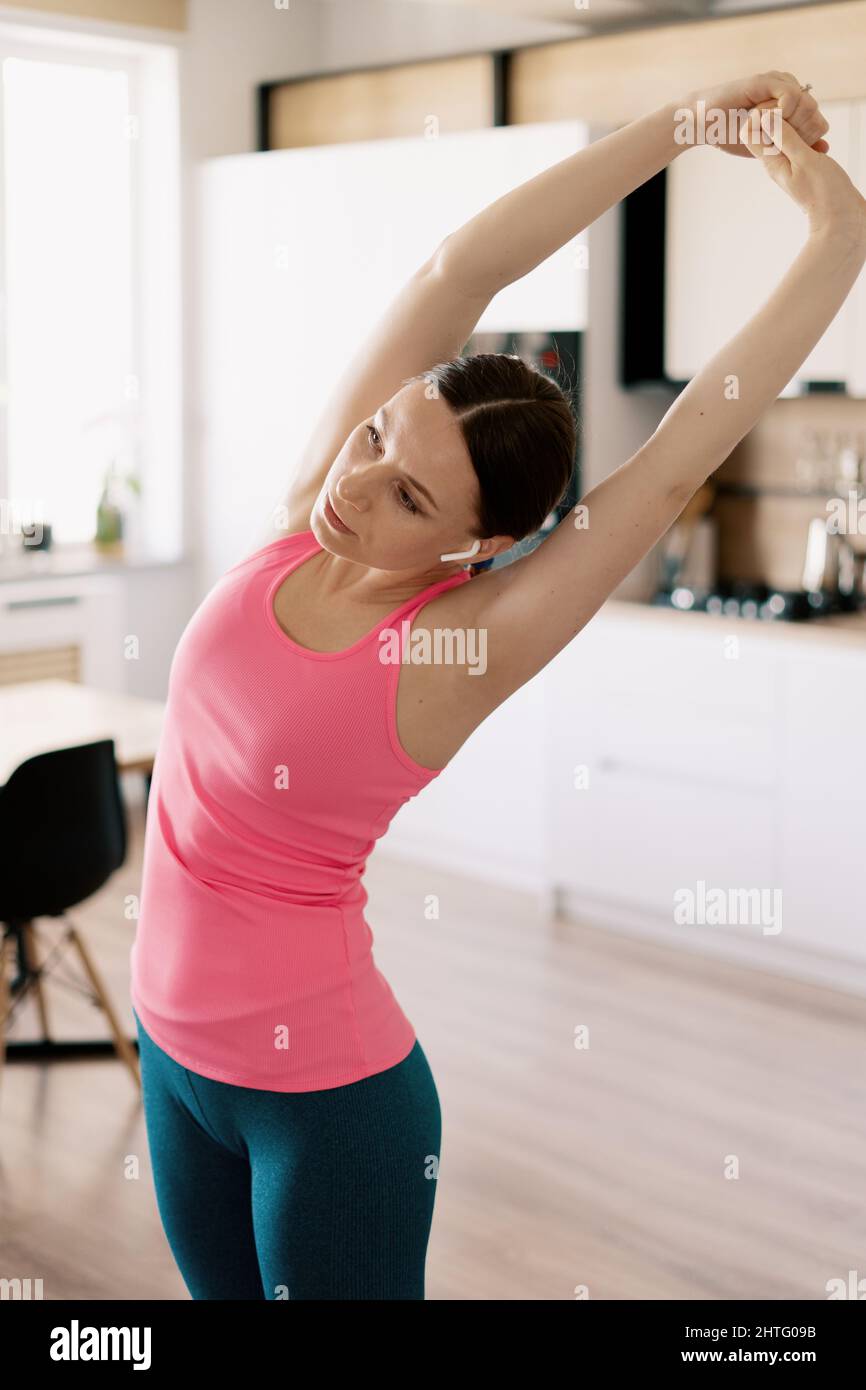 Attractive woman practicing stretching in the leaving room Stock Photo ...