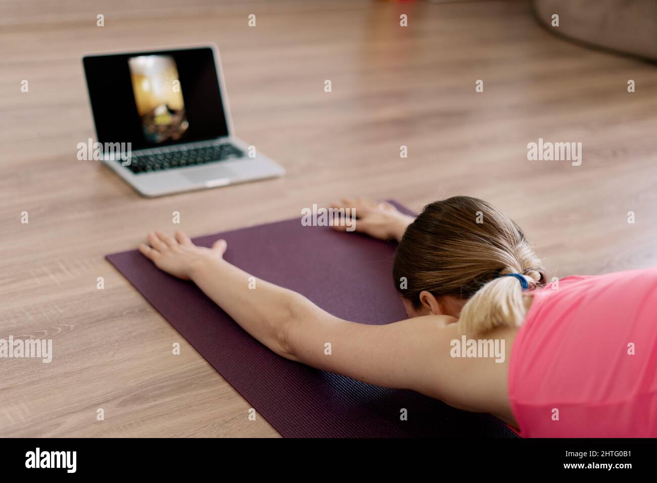 Attractive woman practicing yoga at home using online training ...
