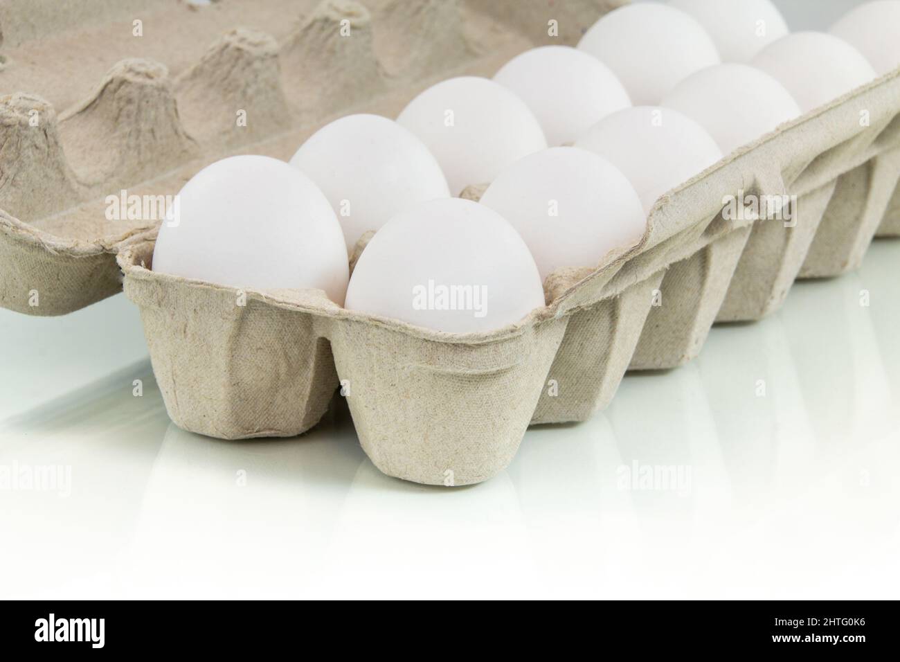 Eggs carton on reflective white background Stock Photo - Alamy