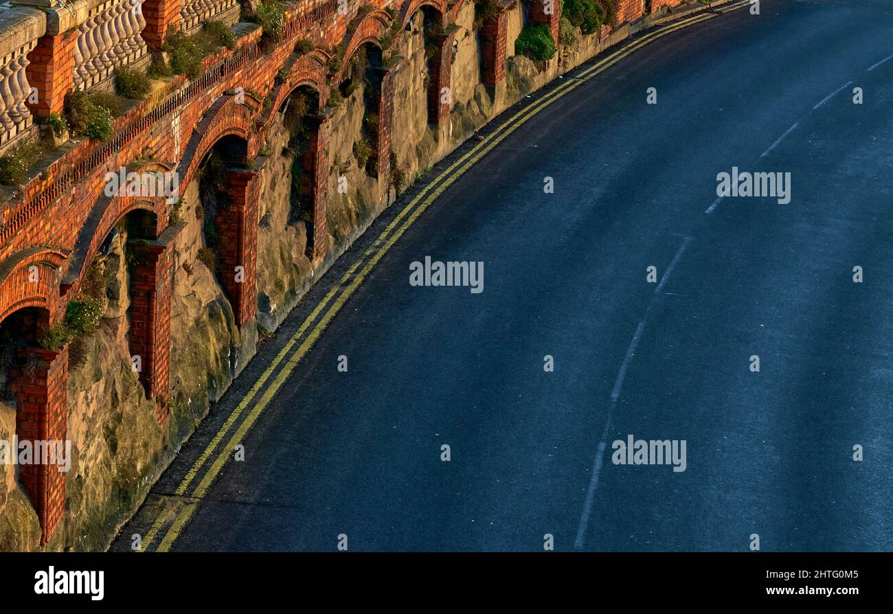 Red brick arches over a black tarmac road Stock Photo - Alamy