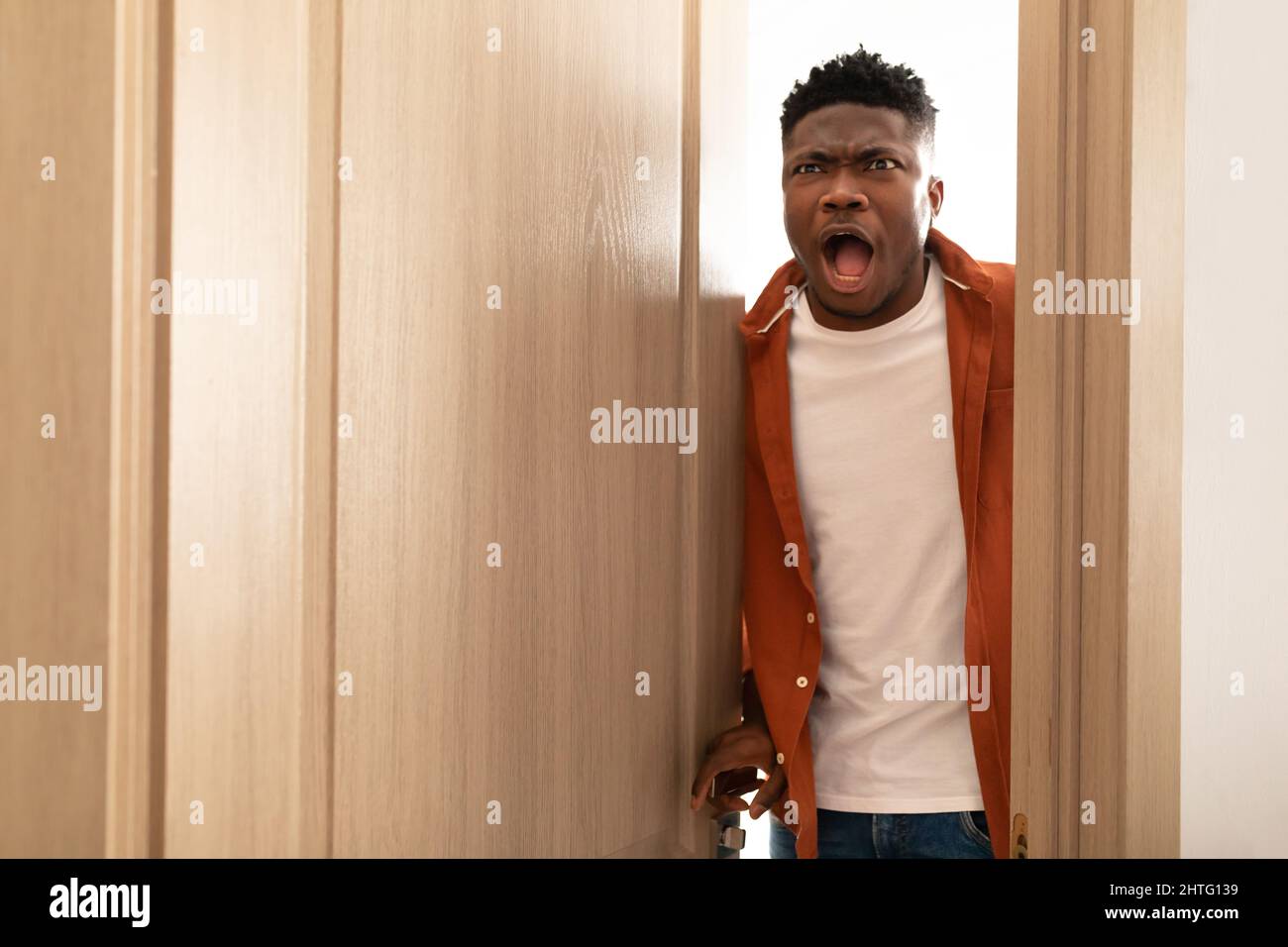 Shocked African American Man Opening The Door Standing At Home Stock ...