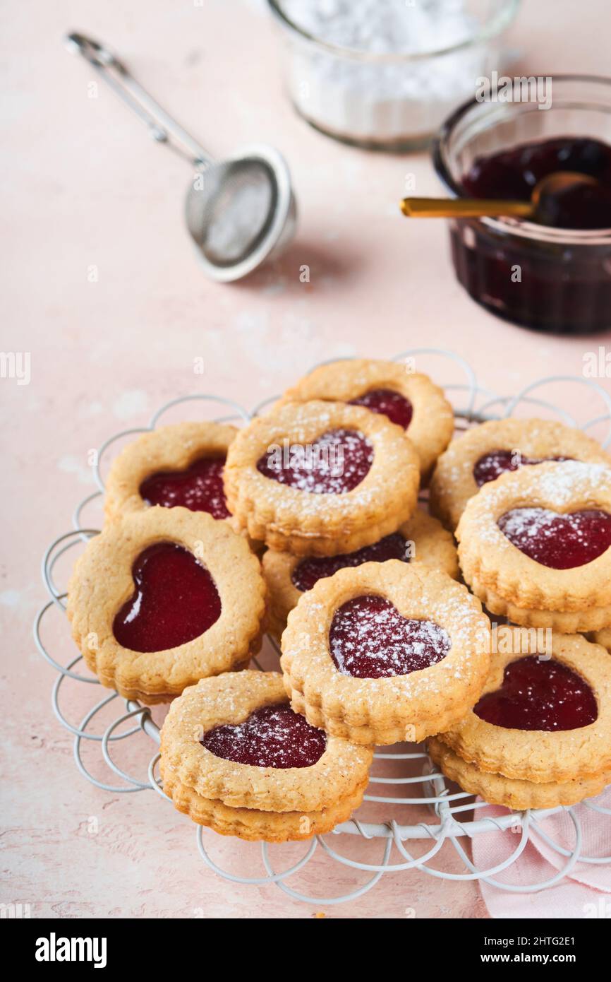 Traditional Linzer cookie with strawberry jam and powder sugar on pink ...