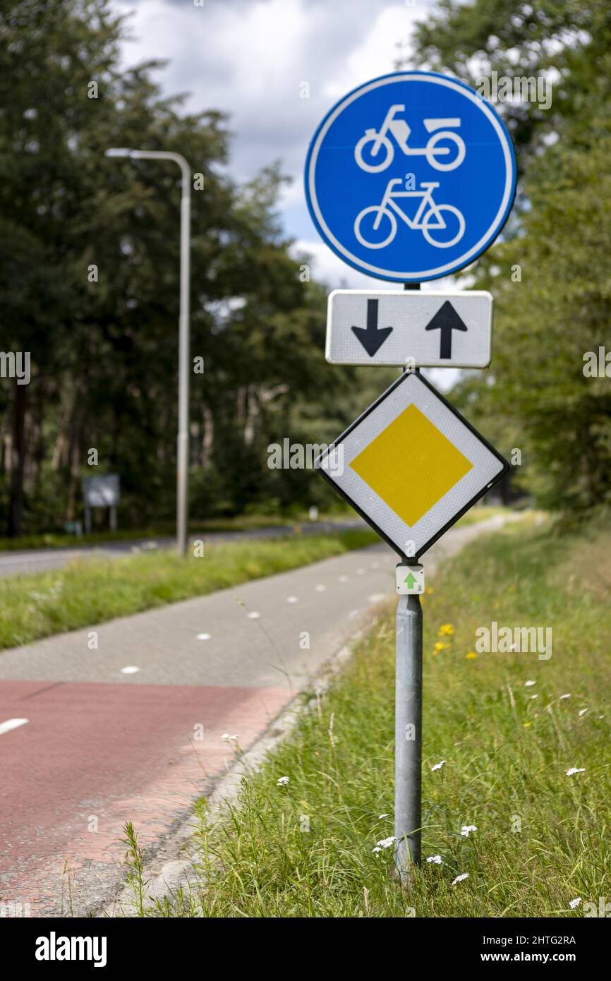 Traffic signs on the side of a bike path and priority road Stock Photo ...