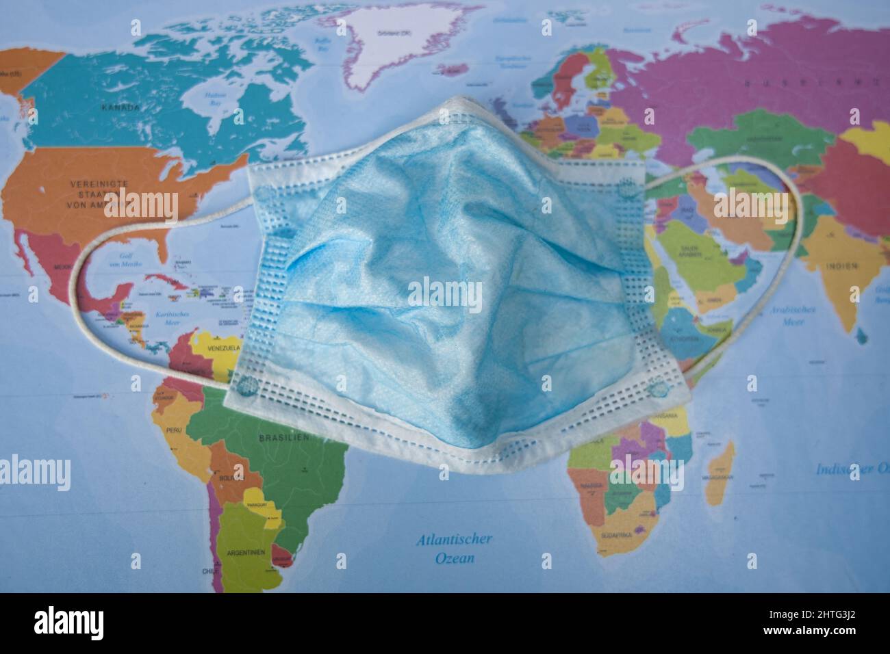 corona breath mask on a world map, focus on mask Stock Photo - Alamy