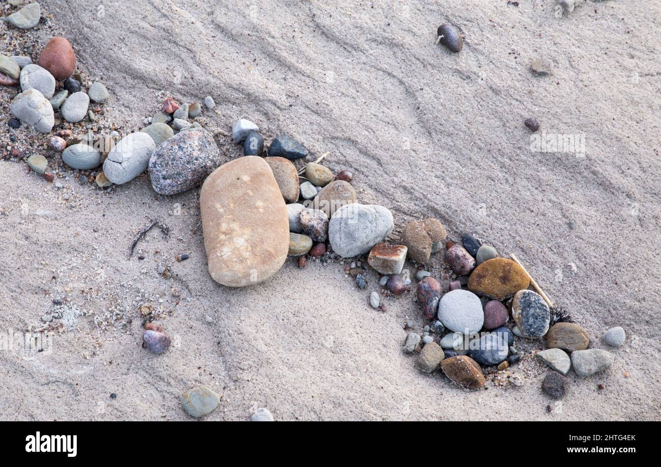 Closeup of small pebbles on a sand Stock Photo - Alamy