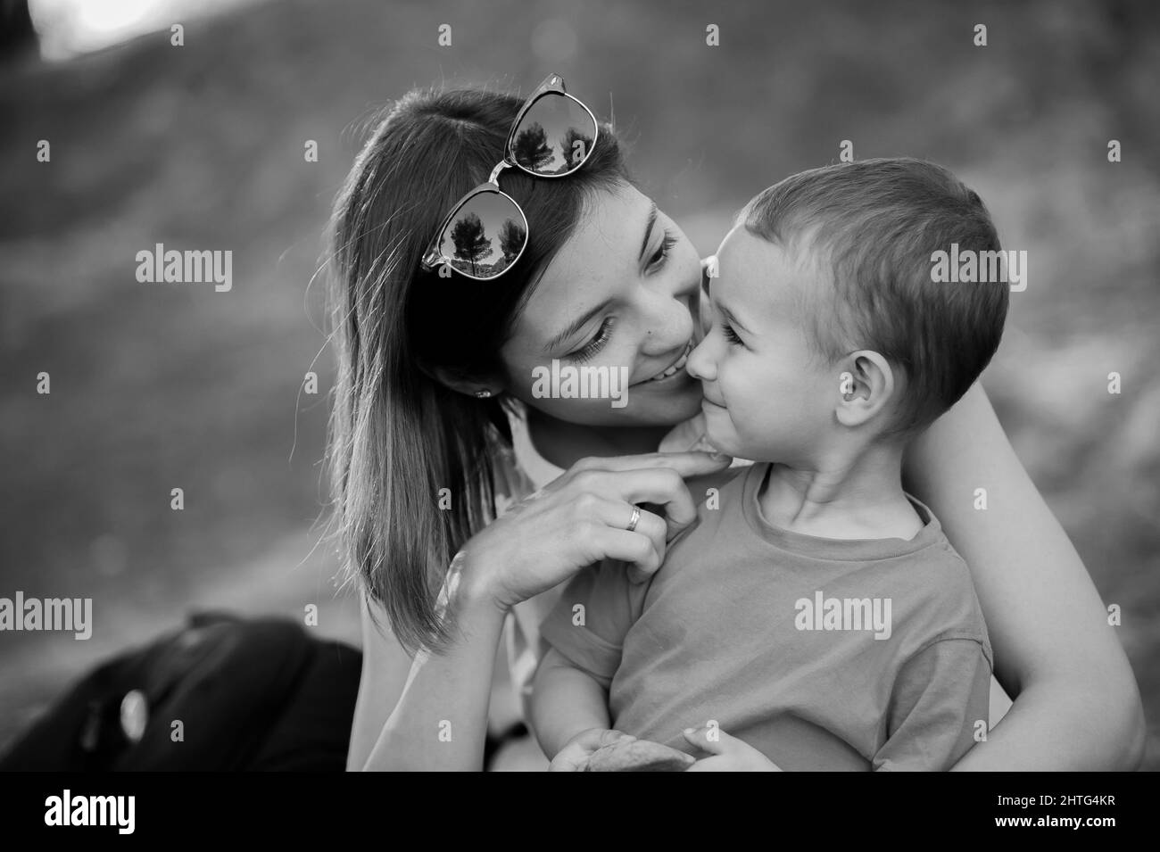 Grayscale of a mother hugging her son and smiling at him Stock Photo - Alamy