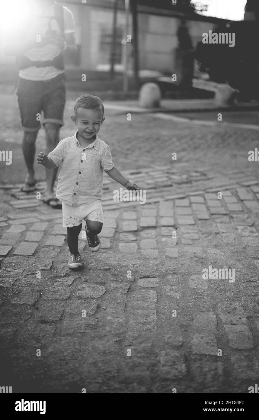 Grayscale vertical picture of a running happy caucasian kid Stock Photo ...