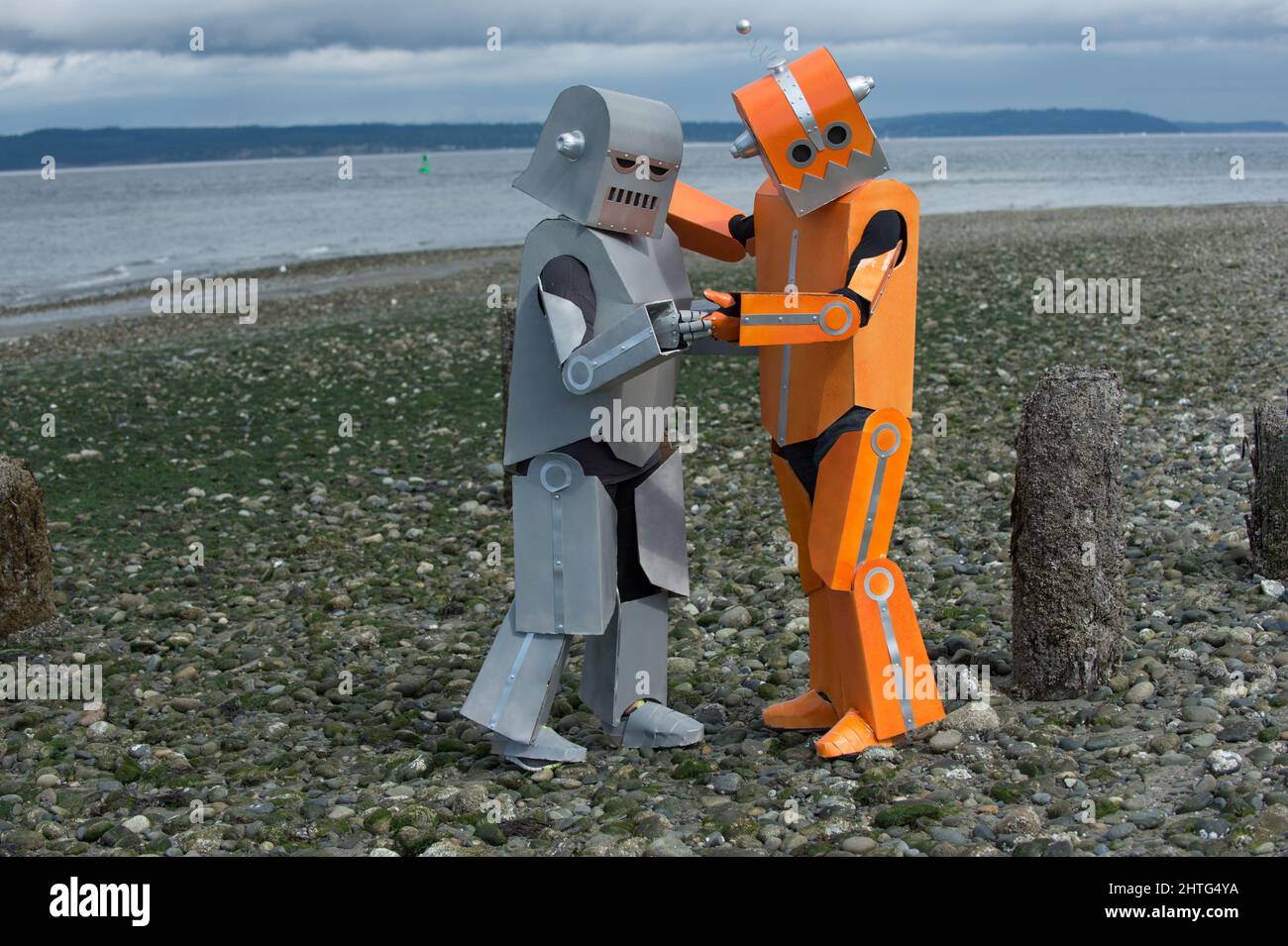 Colorful robots dancing, having fun on the beach. Robots in love or ...