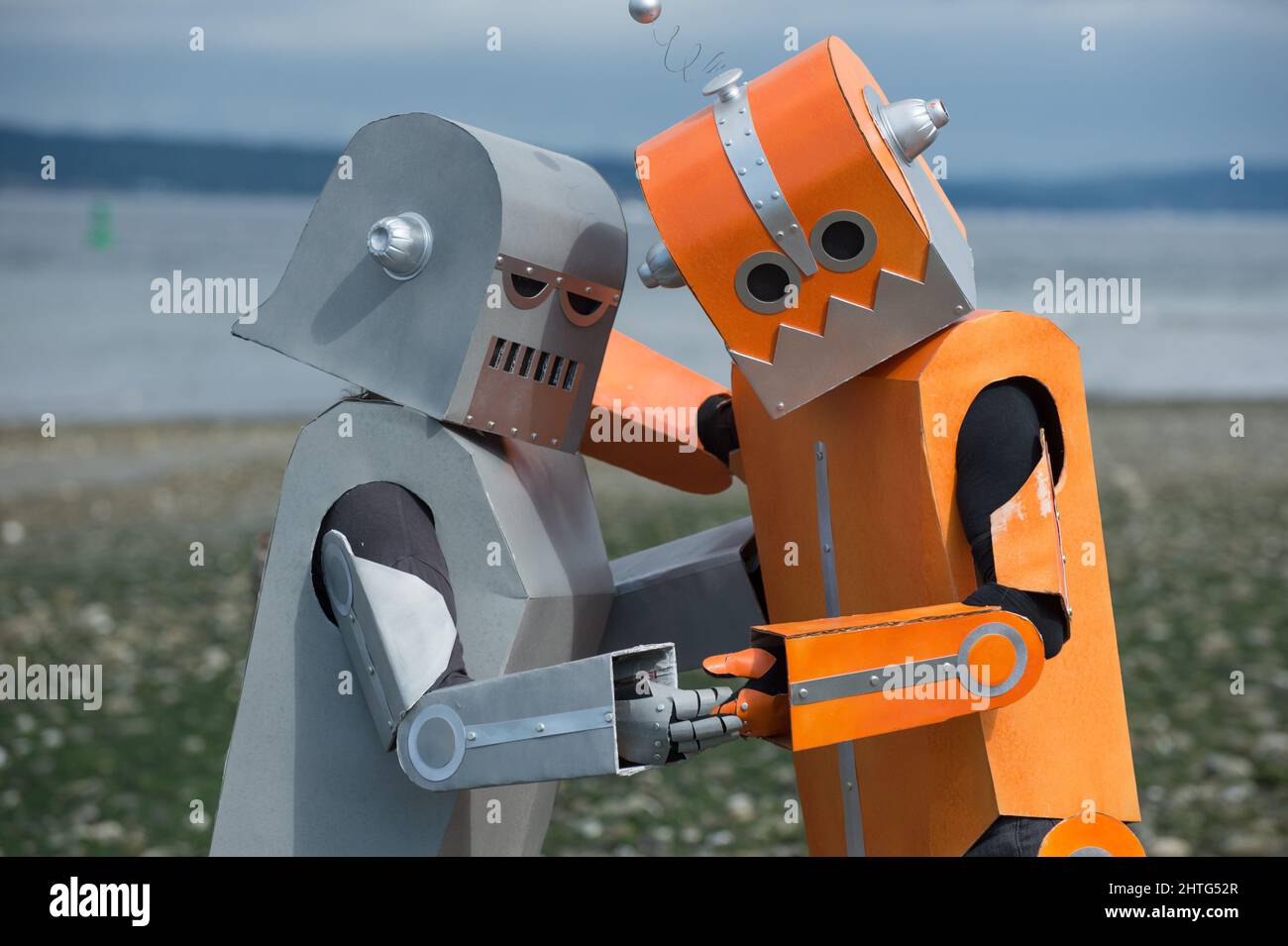 Colorful robots dancing, having fun on the beach. Robots in love or ...