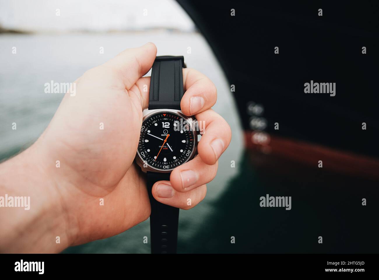 Male hand holding black wristwatch in the blurred background Stock ...