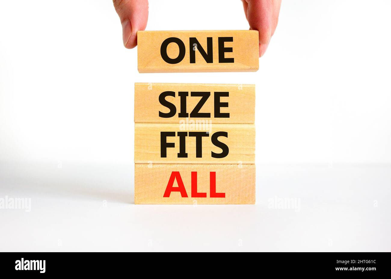 One size fits all symbol. Concept words One size fits all on wooden blocks. Businessman hand ...