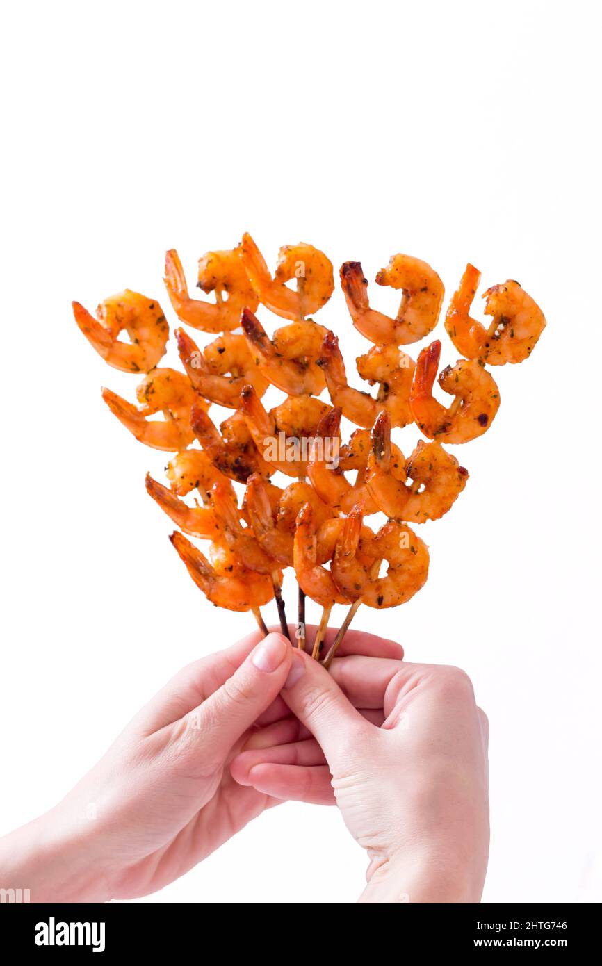 Hand holding Roasted peel prawn skewer sticks isolated on a white ...
