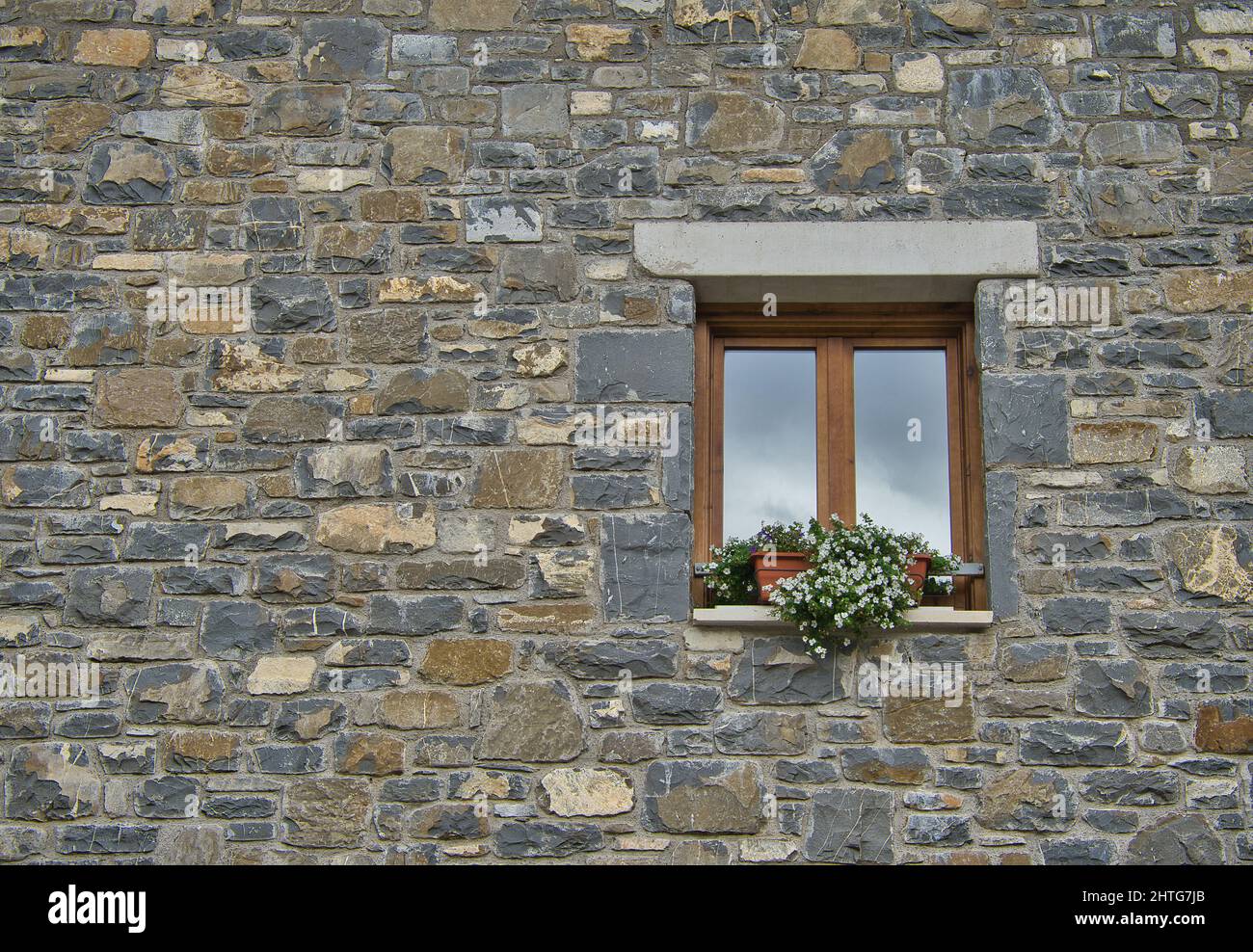 Stone rural house with plants on a windowsill in the Pyrenees Stock ...