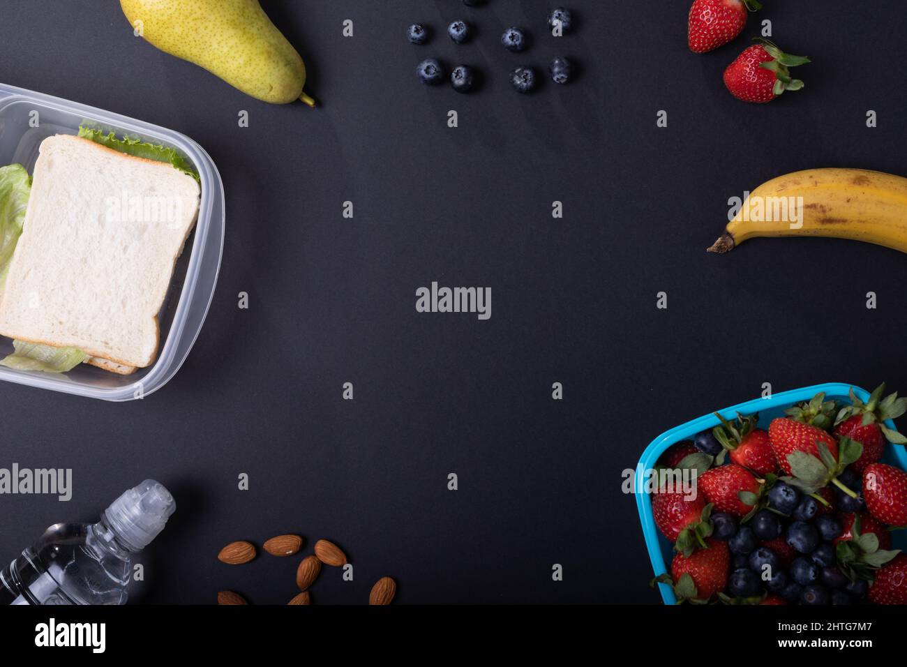 Overhead view of healthy food with lunch box over black background ...