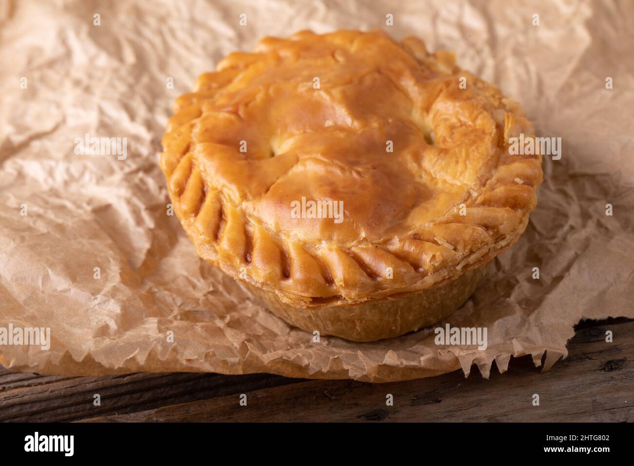 High angle close-up of baked stuffed pie on brown wax paper Stock Photo ...