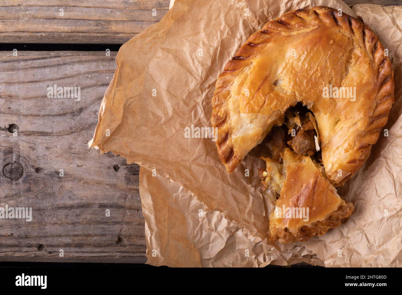 Directly above shot of sliced baked stuffed pie in brown wax paper on ...