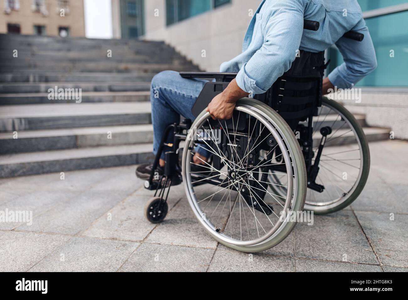 Closeup of young black man in wheelchair in front of stairs without ...