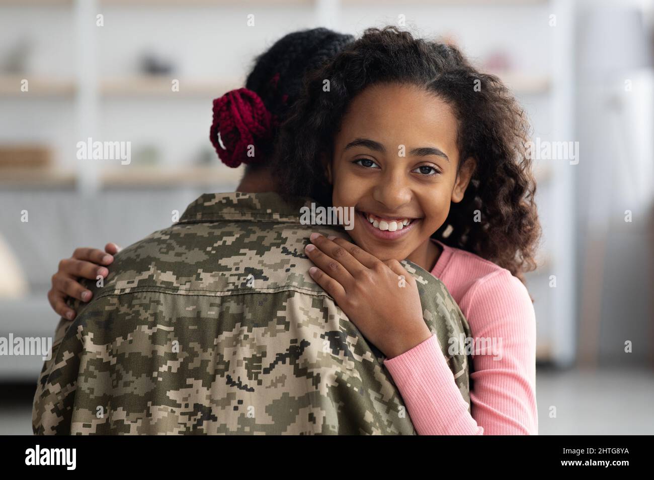 Portrait of happy african american teen girl hugging mom soldier Stock ...