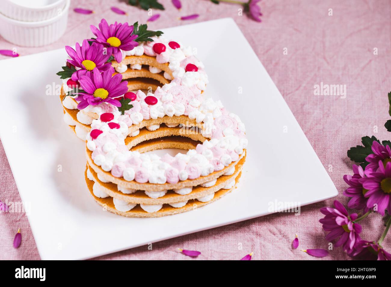 Women's day cake in the shape of number eight on pink background. 8 ...