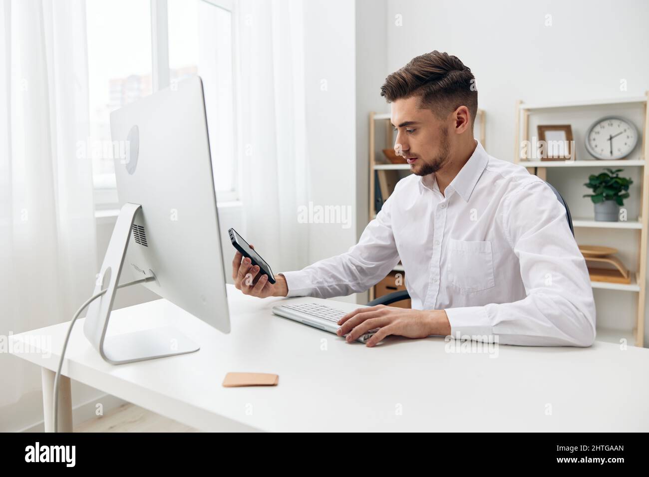 manager sitting at a desk in front of a computer with a keyboard ...