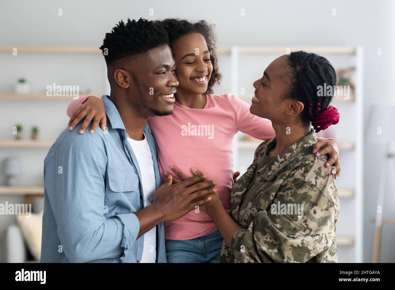 Happy african american family greeting mother soldier Stock Photo - Alamy
