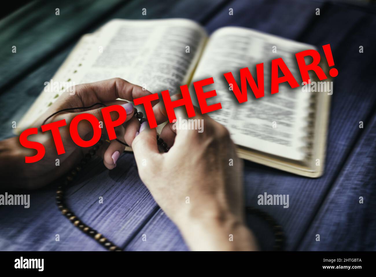 Stop war - inscription. Background of blurred female hand and bible in ...