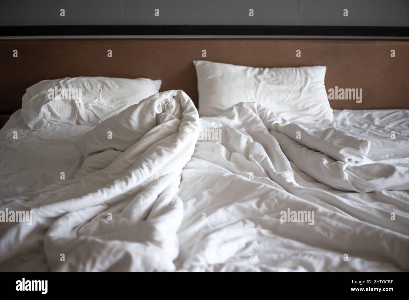 a crumpled white bed on a large bed in the house. Family life, night ...