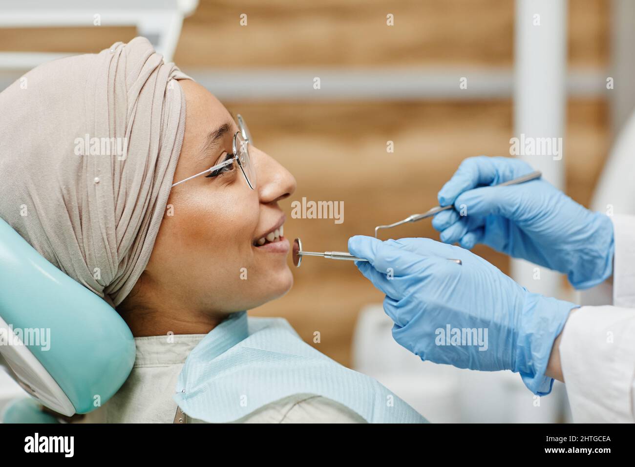 Side view portrait of young Middle-Eastern woman smiling while laying ...