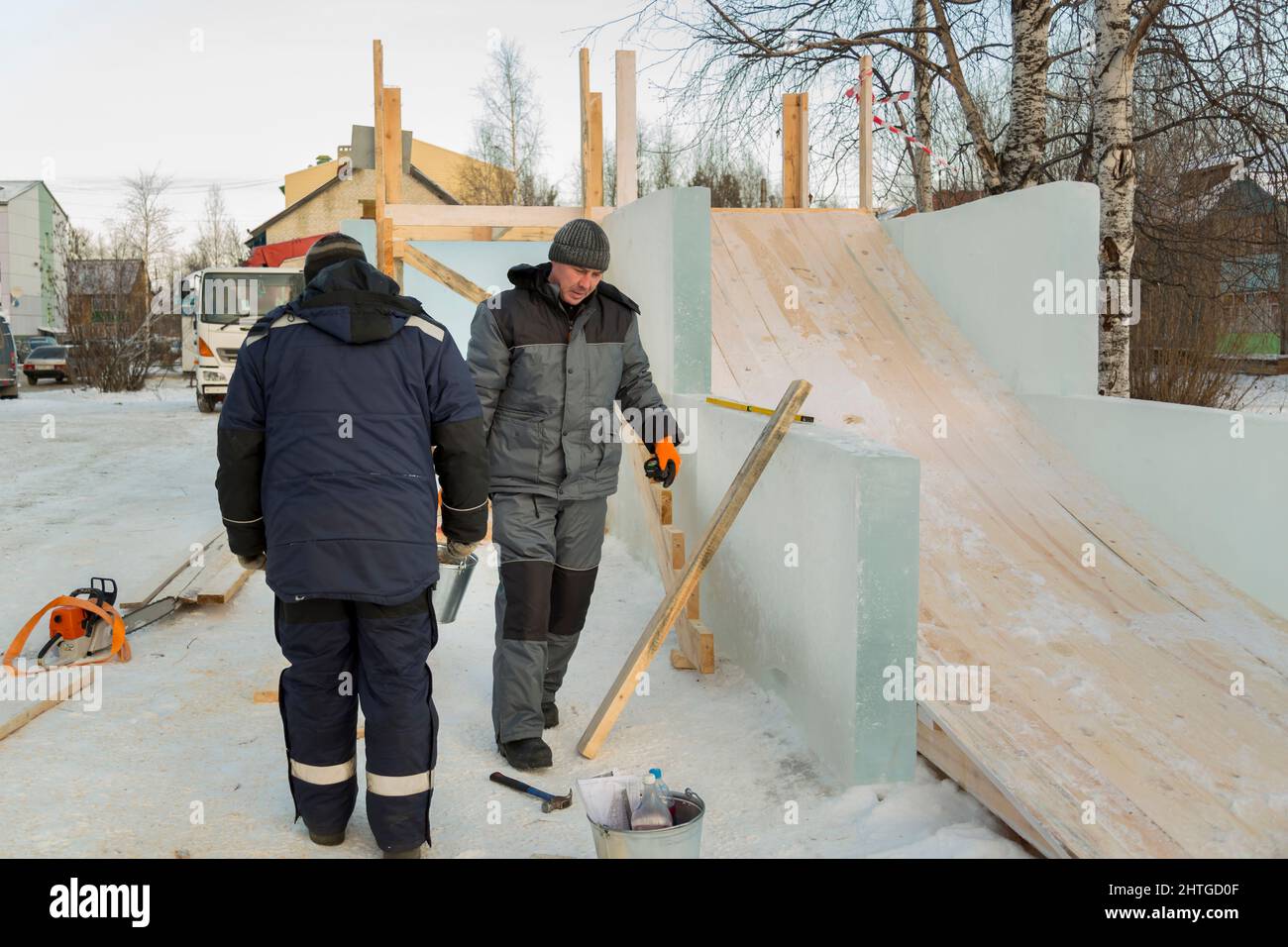 Two workers assemble the slide frame from wooden beams Stock Photo - Alamy