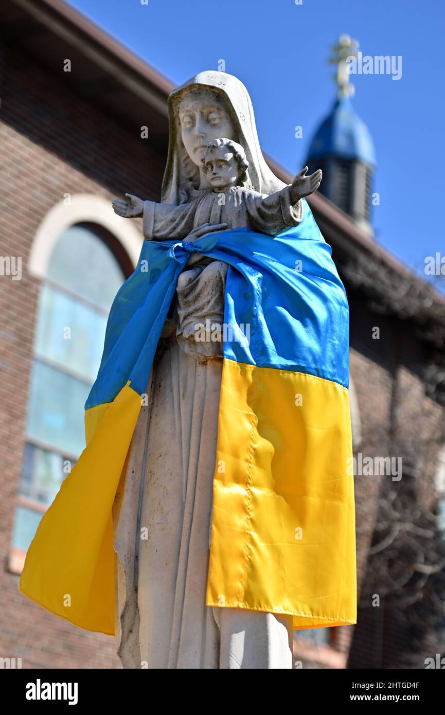 The flag of Ukraine has been tied around a statue of the Virgin Mary ...