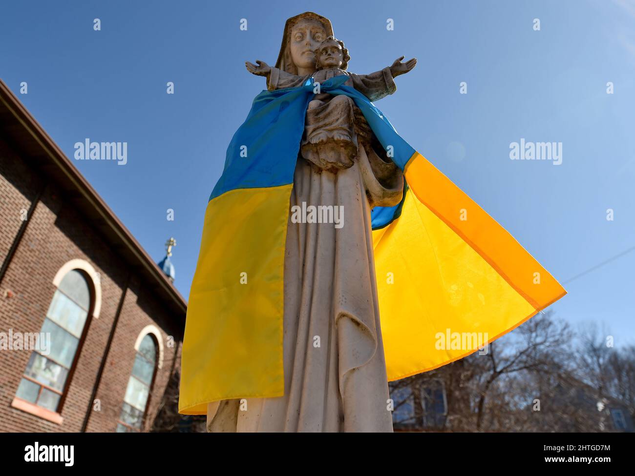 The flag of Ukraine has been tied around a statue of the Virgin Mary ...