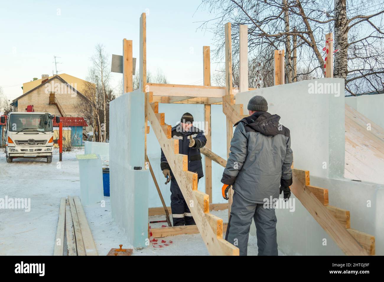 Two workers assemble the slide frame from wooden beams Stock Photo - Alamy